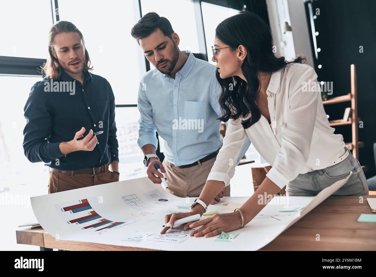 Best team ever. Group of young confident business people discussing ...