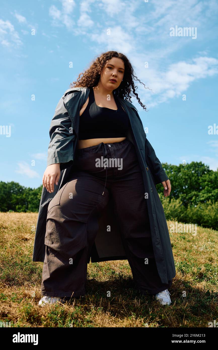 A beautiful plus size woman stands tall in nature, embracing the warmth ...