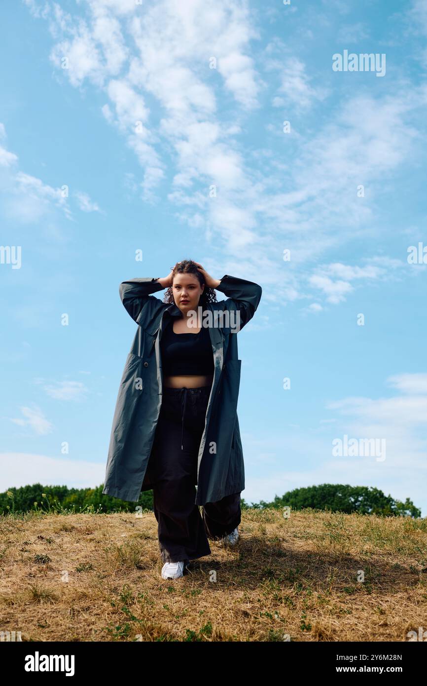 A confident plus size woman poses gracefully in a lush green field ...