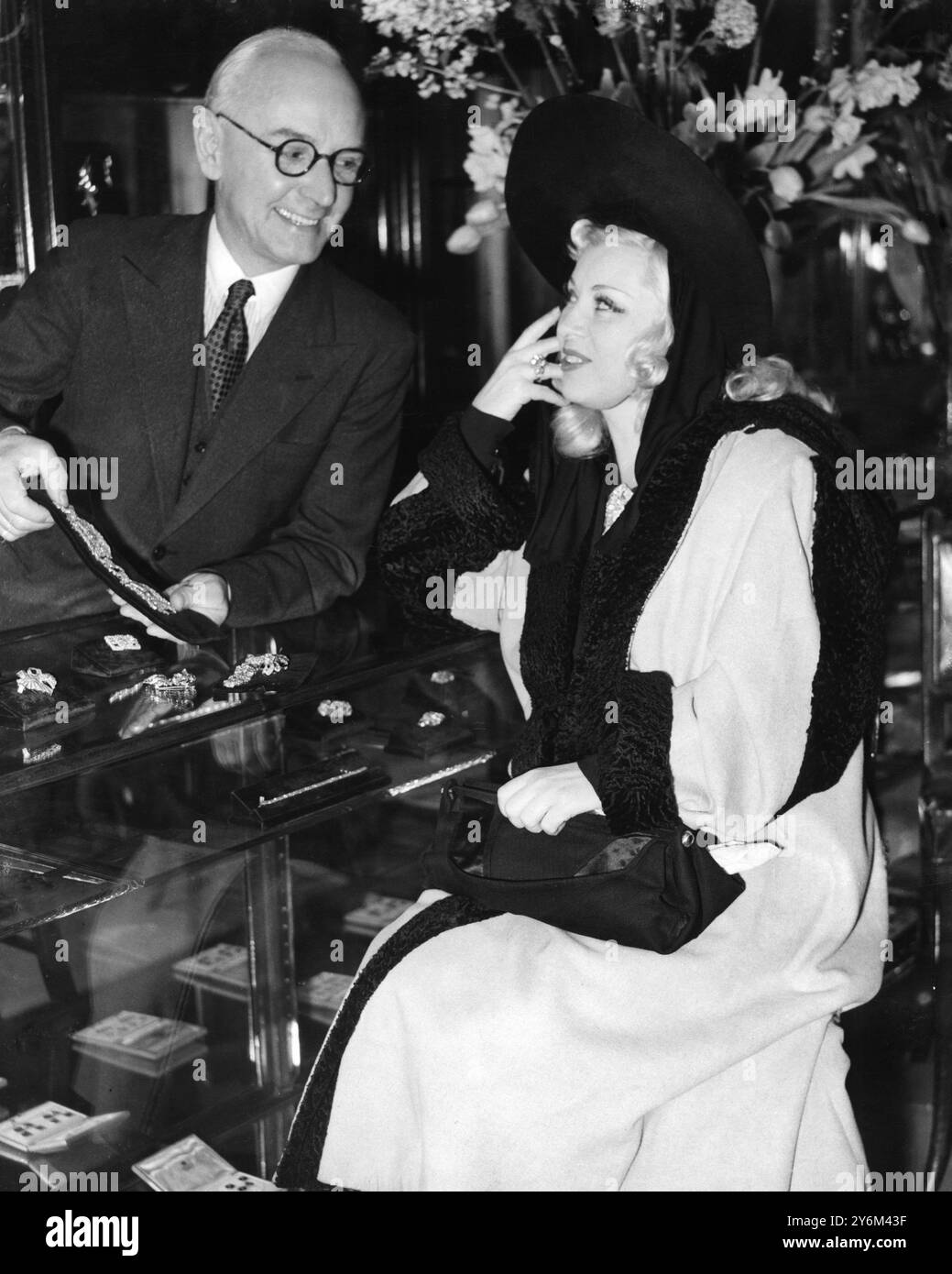 Mae West, star of the American show "Diamond Lil" looks over a diamond ...