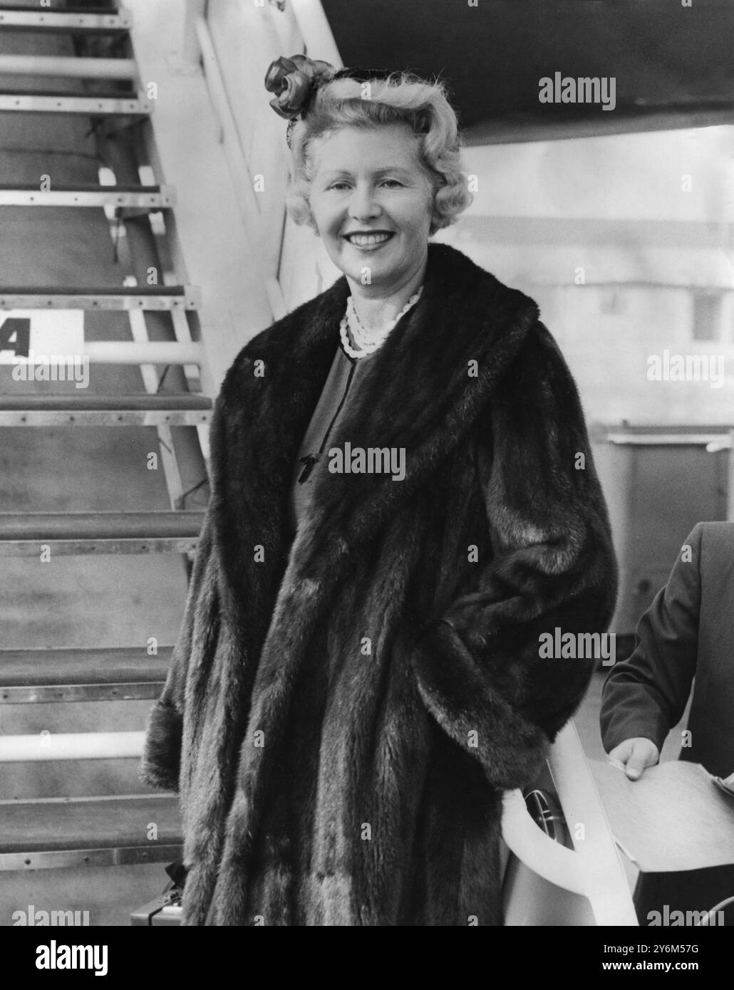 Clad in a luxurious fur coat, Hollywood columnist Sheila Graham arrives ...