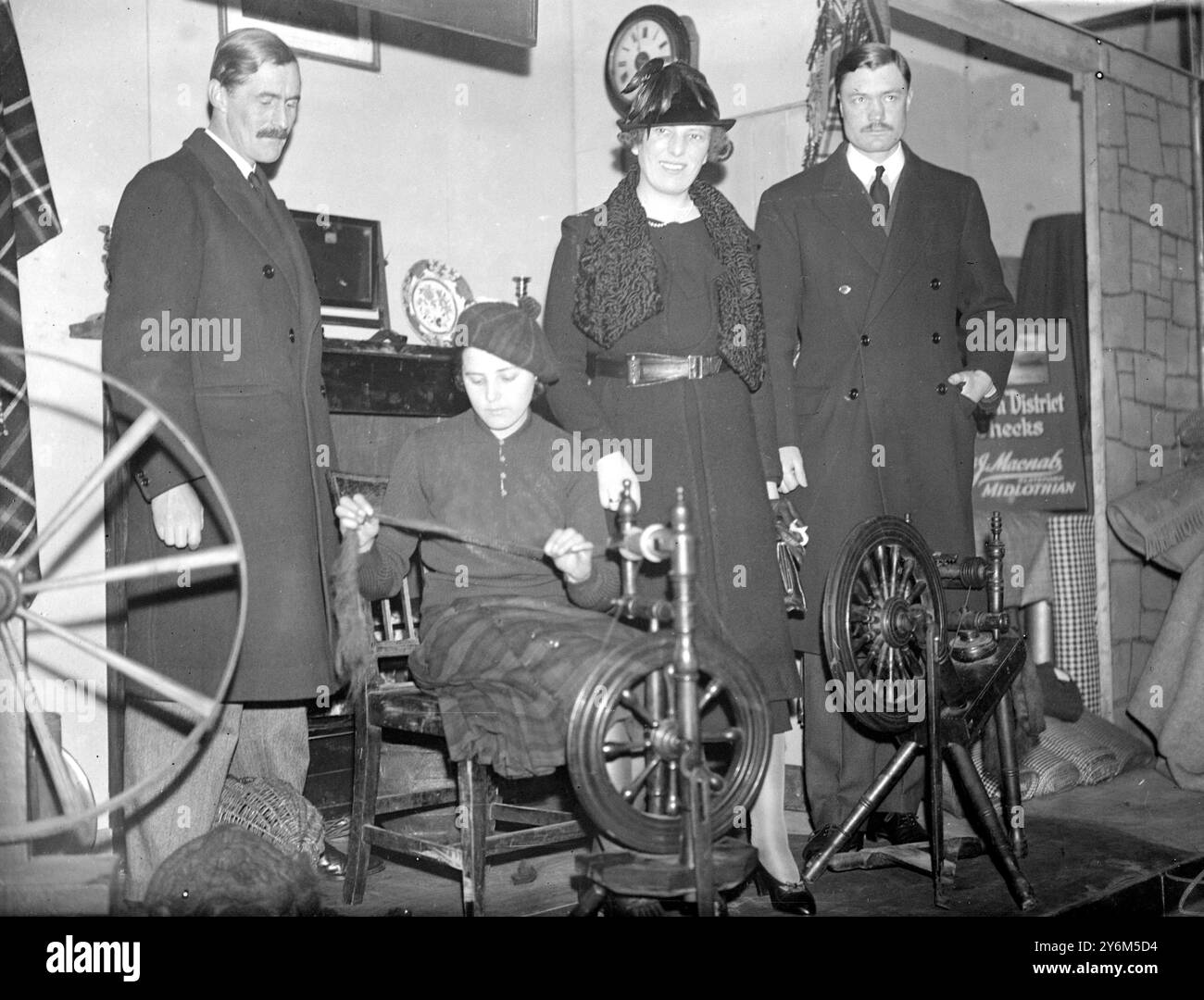Mrs Walter Elliott with a Scots lassie at her spinning wheel, on the ...