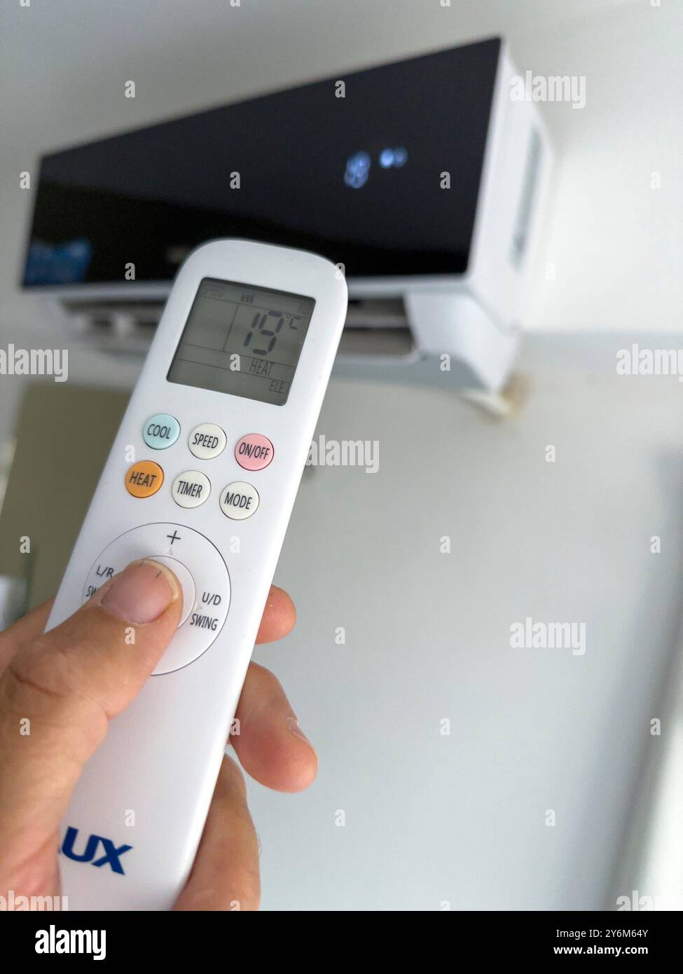 Air conditioner. Temperature adjustment by remote control at 19°C Stock ...