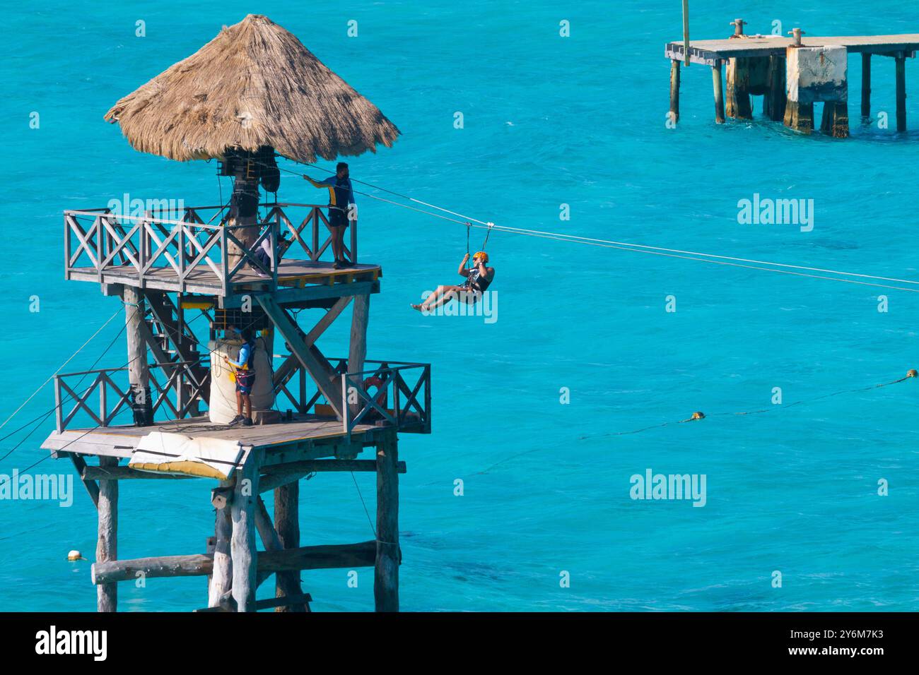 Mexico, State of Quintana Roo, Isla Mujeres. Tourist on a zip line over ...