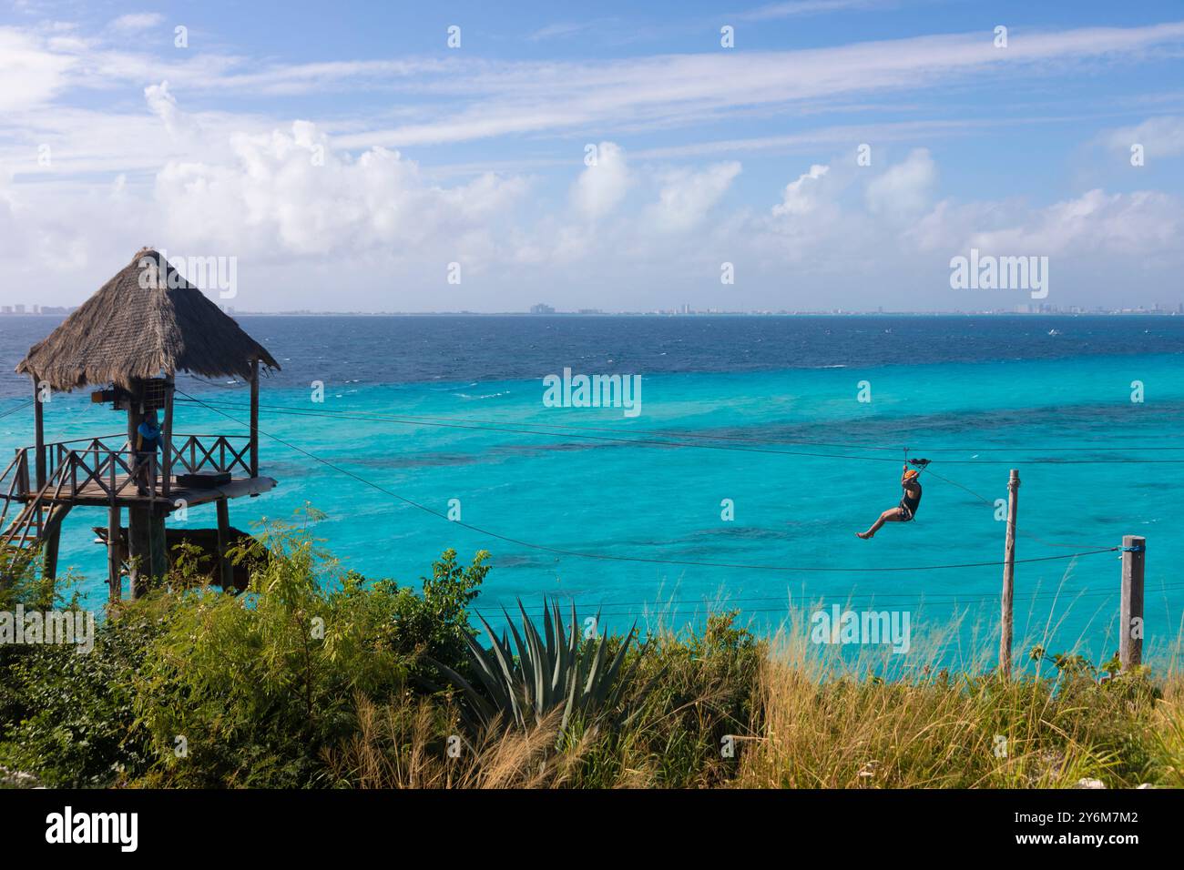 Mexico, State of Quintana Roo, Isla Mujeres. Tourist on a zip line over ...
