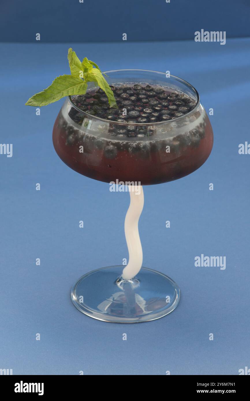 Stylish and refined, the burgundy cocktail in a white wavy-stemmed ...