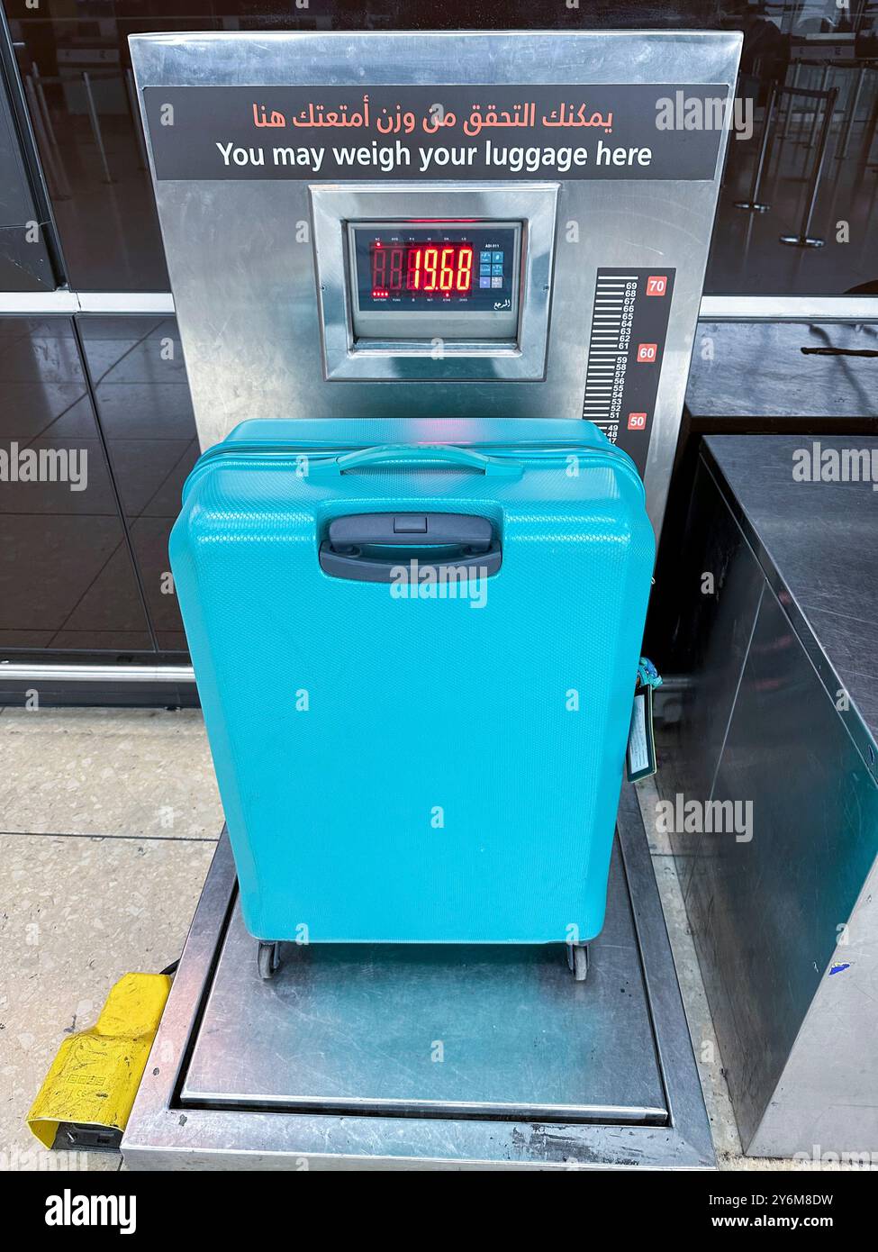 Suitcase on a scale in an airport Stock Photo - Alamy