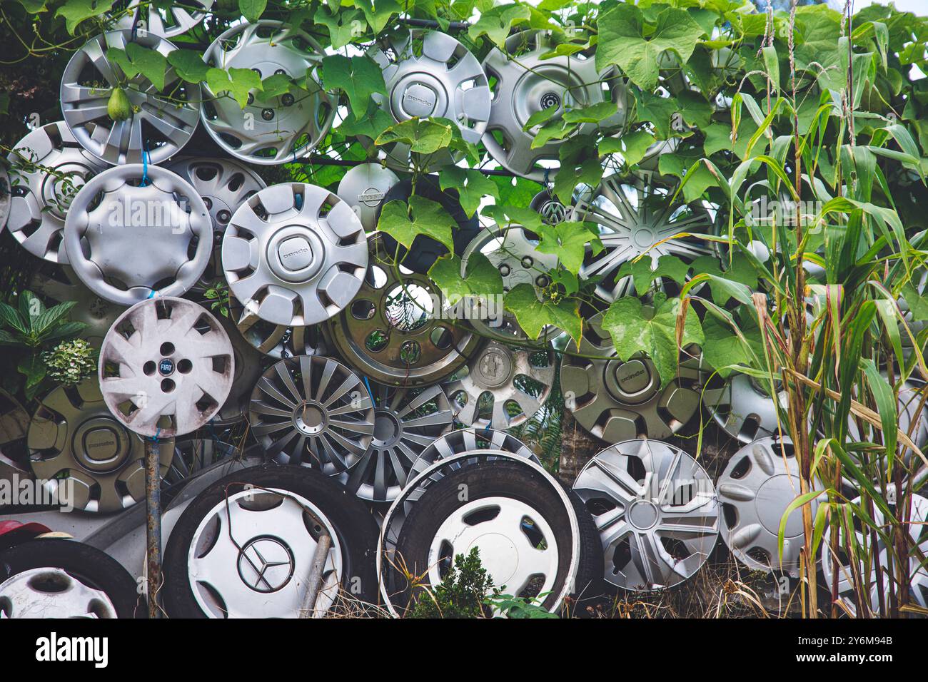 Decorative hubcaps in a garden Stock Photo - Alamy