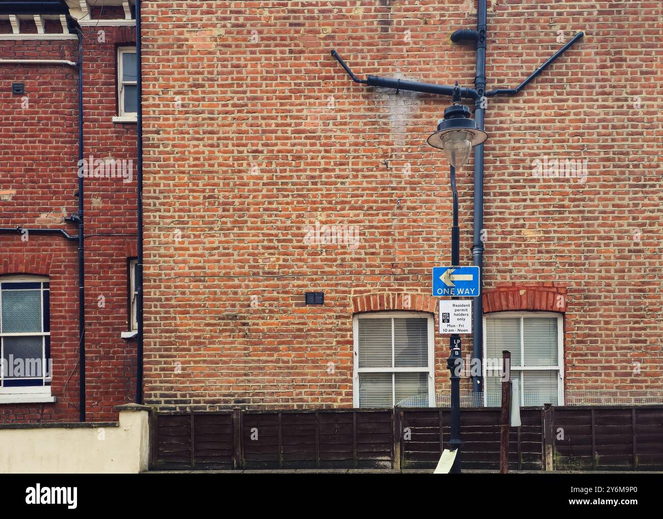 London houses with brick walls showing a traffic one way sign and a ...