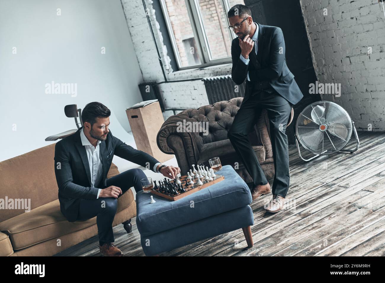 Passionate about chess. Young thoughtful men in full suits playing ...
