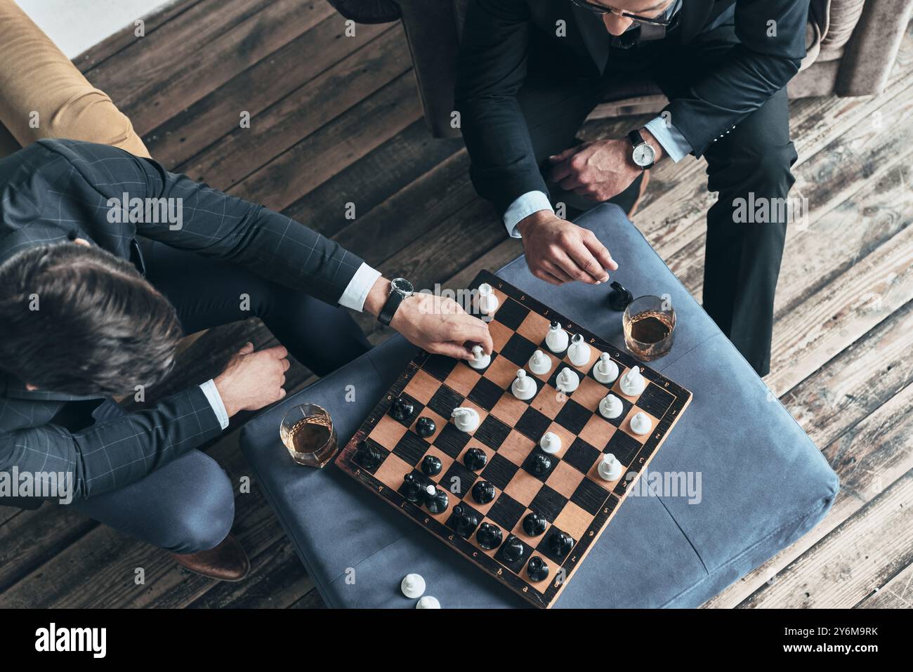 Think hard before the move. Top view of young thoughtful men in full ...