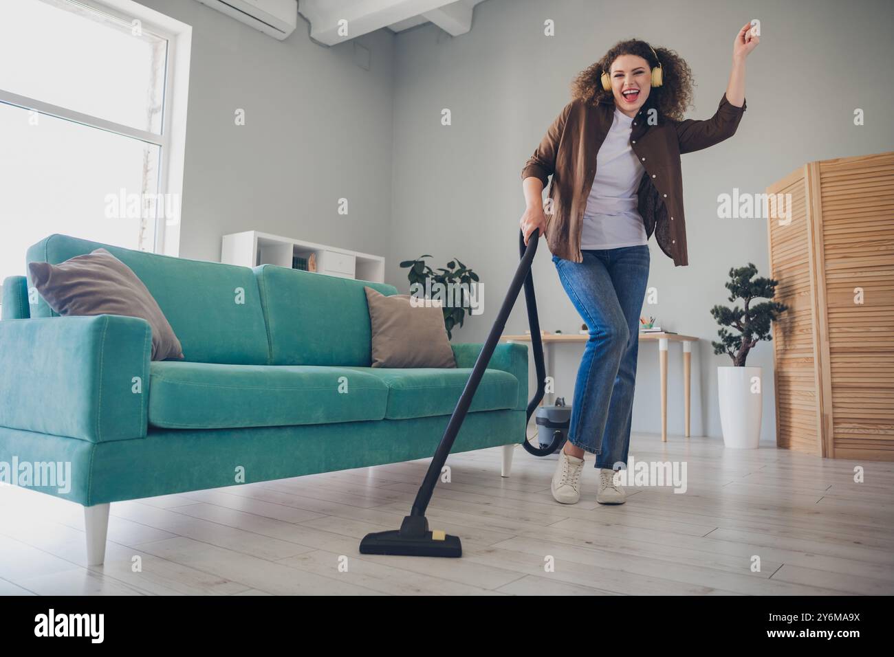 Photo of charming brunette wavy hair lady using vacuum cleaner pefect ...