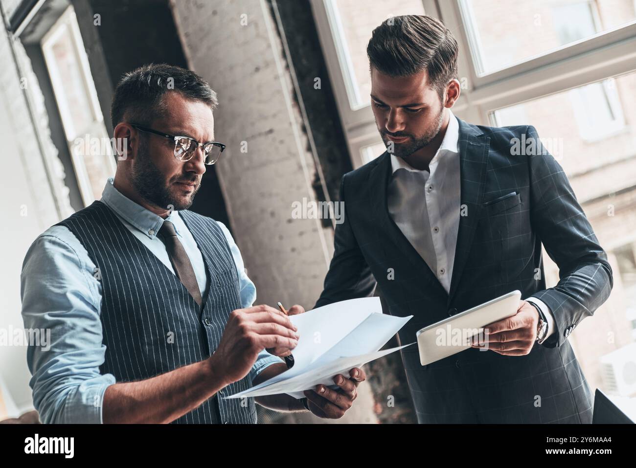 Successful professionals. Two young modern men in formalwear working ...