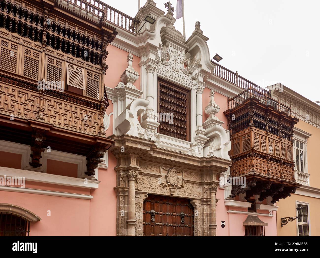 Elegant colonial building facade with intricate wooden balconies and ...