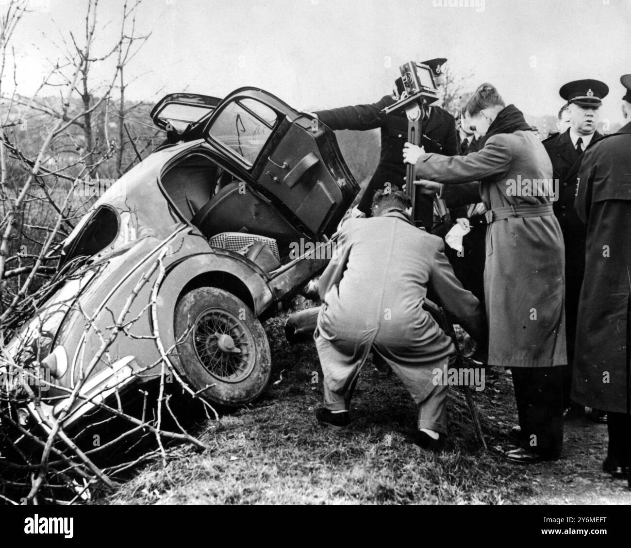 Police and photographers are seen with the wreck of the black Jaguar ...