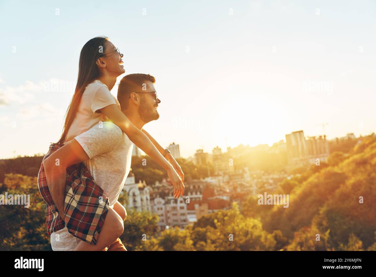 Romantic young couple having fun while man giving his girlfriend piggy back ride Stock Photo - Alamy