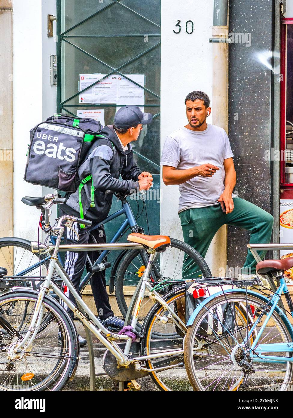 Restaurant worker and food delivery man talking on pavement - Tours ...