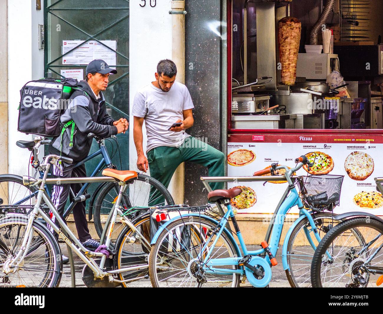 Restaurant worker and food delivery man talking on pavement - Tours ...