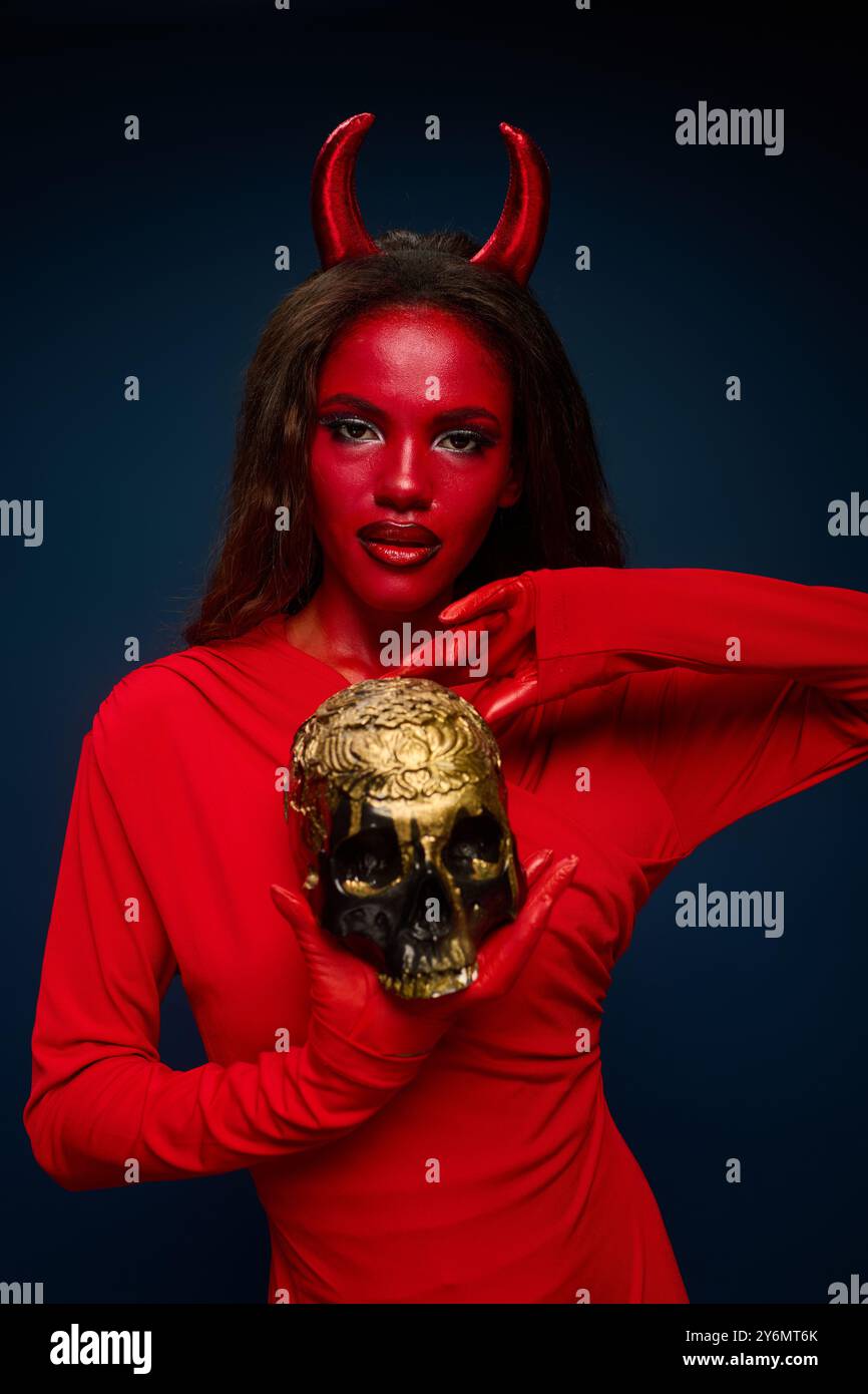 The captivating woman in a red devil costume poses confidently ...