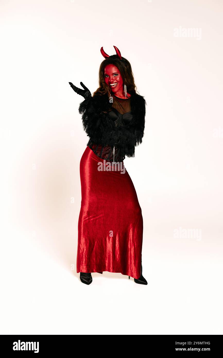 Dressed in a bold red devil outfit, the woman radiates Halloween charm ...