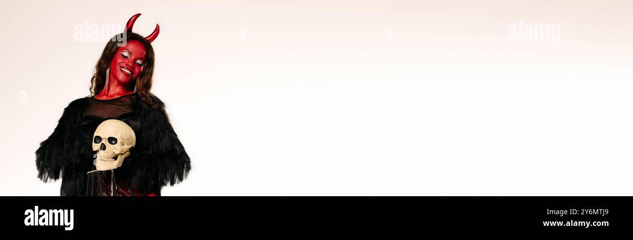 A captivating woman dressed as a devil holds a skull, embodying ...