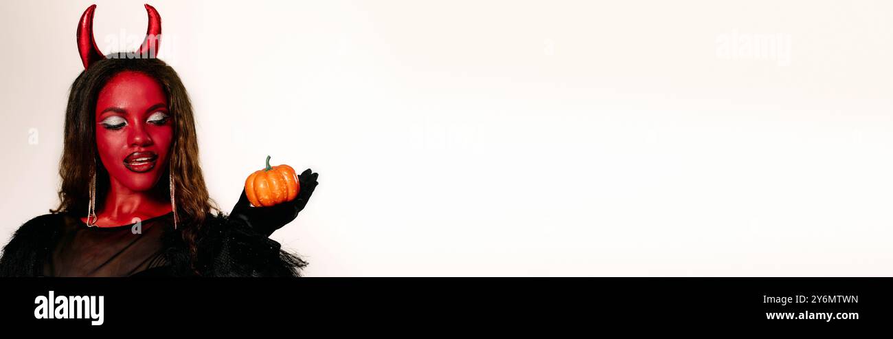 The stylish woman in a devil costume displays her Halloween spirit with ...