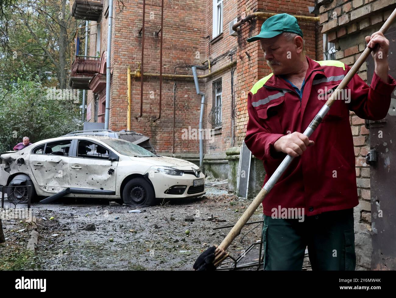 Utility workers clean up after an explosion near an apartment building ...
