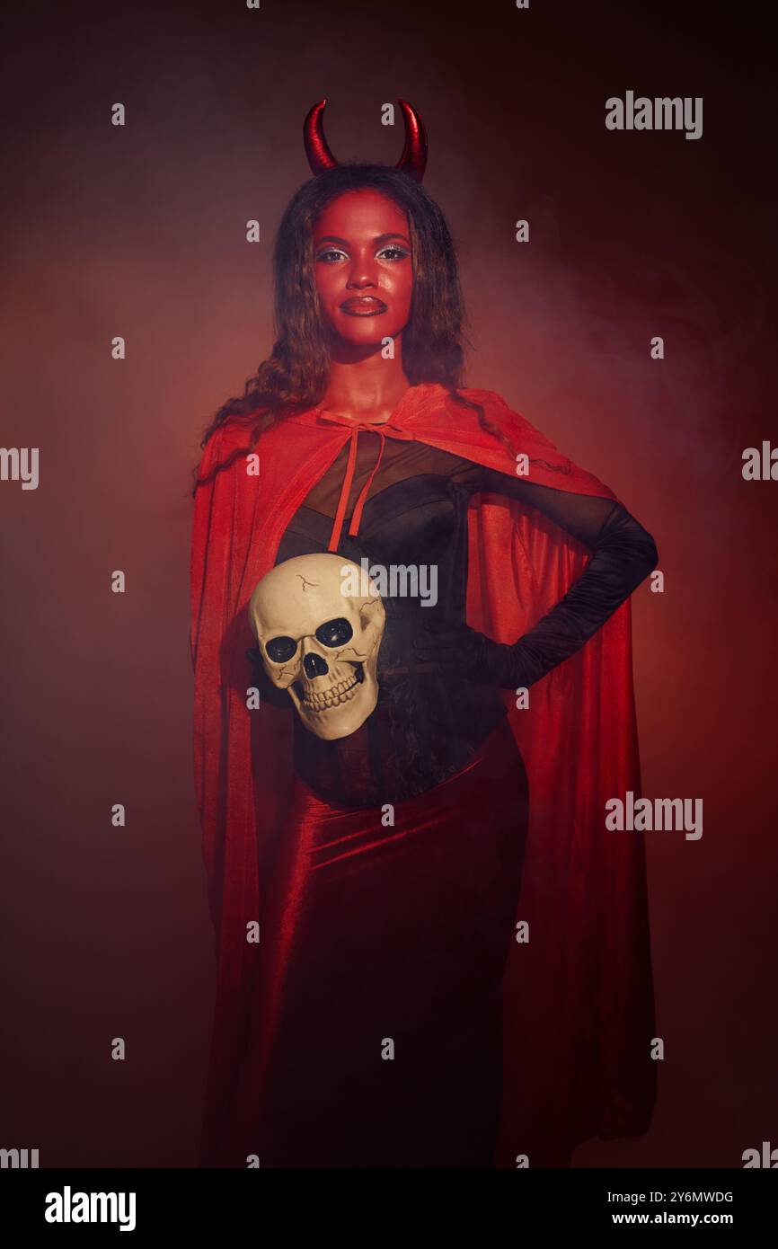 A striking woman dressed as a devil poses confidently, showcasing her ...