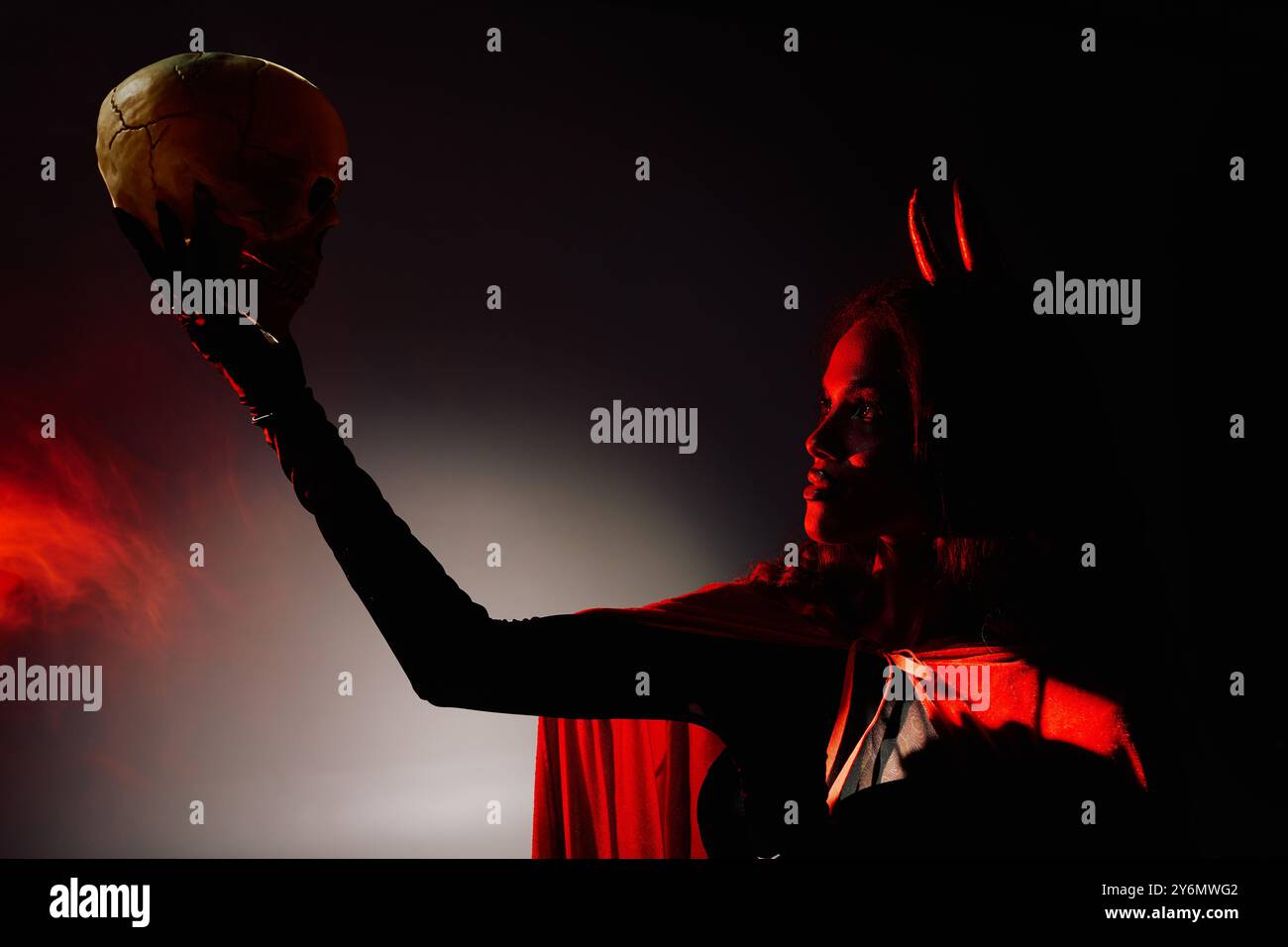 A striking woman showcases her Halloween costume, holding a skull under ...