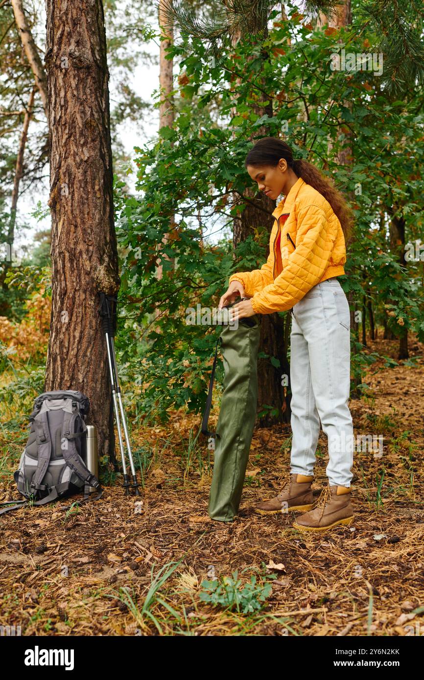 Exploring the vibrant autumn forest, a young woman prepares for an ...