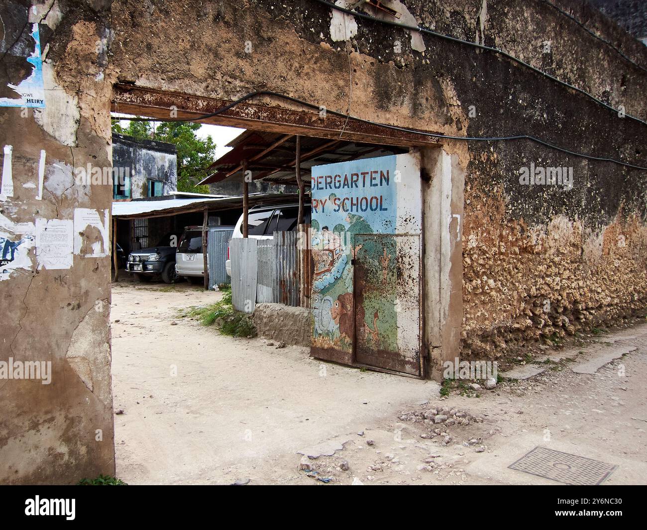 An old, textured gate marks the entrance to a kindergarten in Zanzibar ...