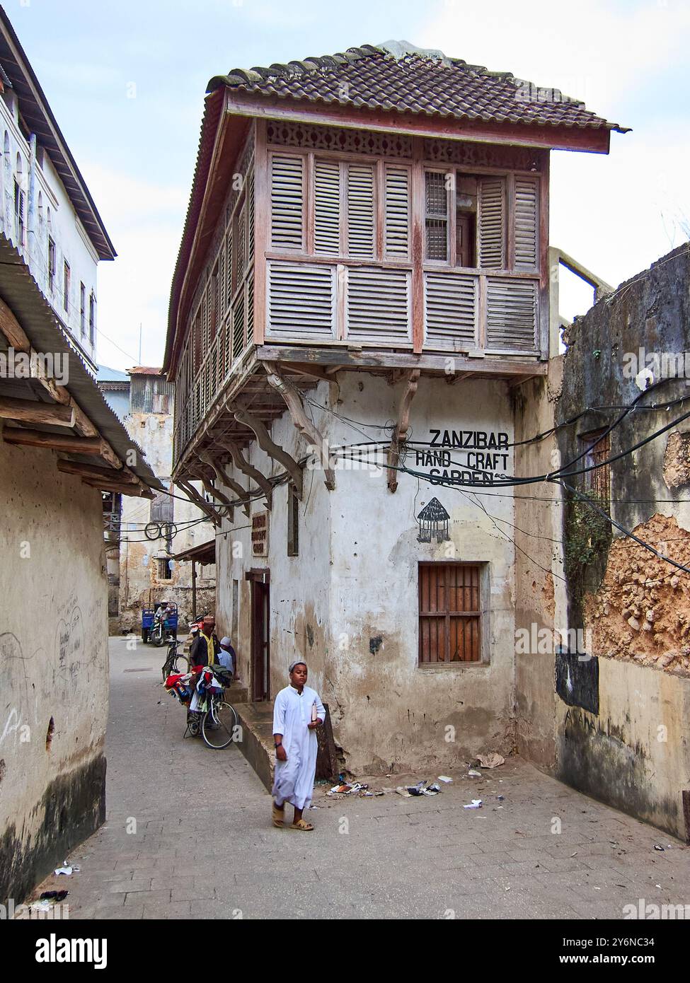 A view of a traditional narrow street in Stone Town, Zanzibar, showcasing rustic architecture ...