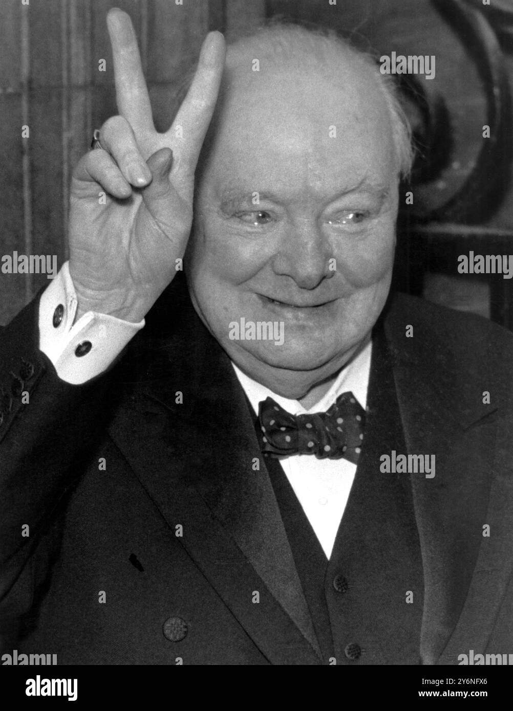 Sir Winston Churchill gives his well-known "V" sign as he arrives back ...