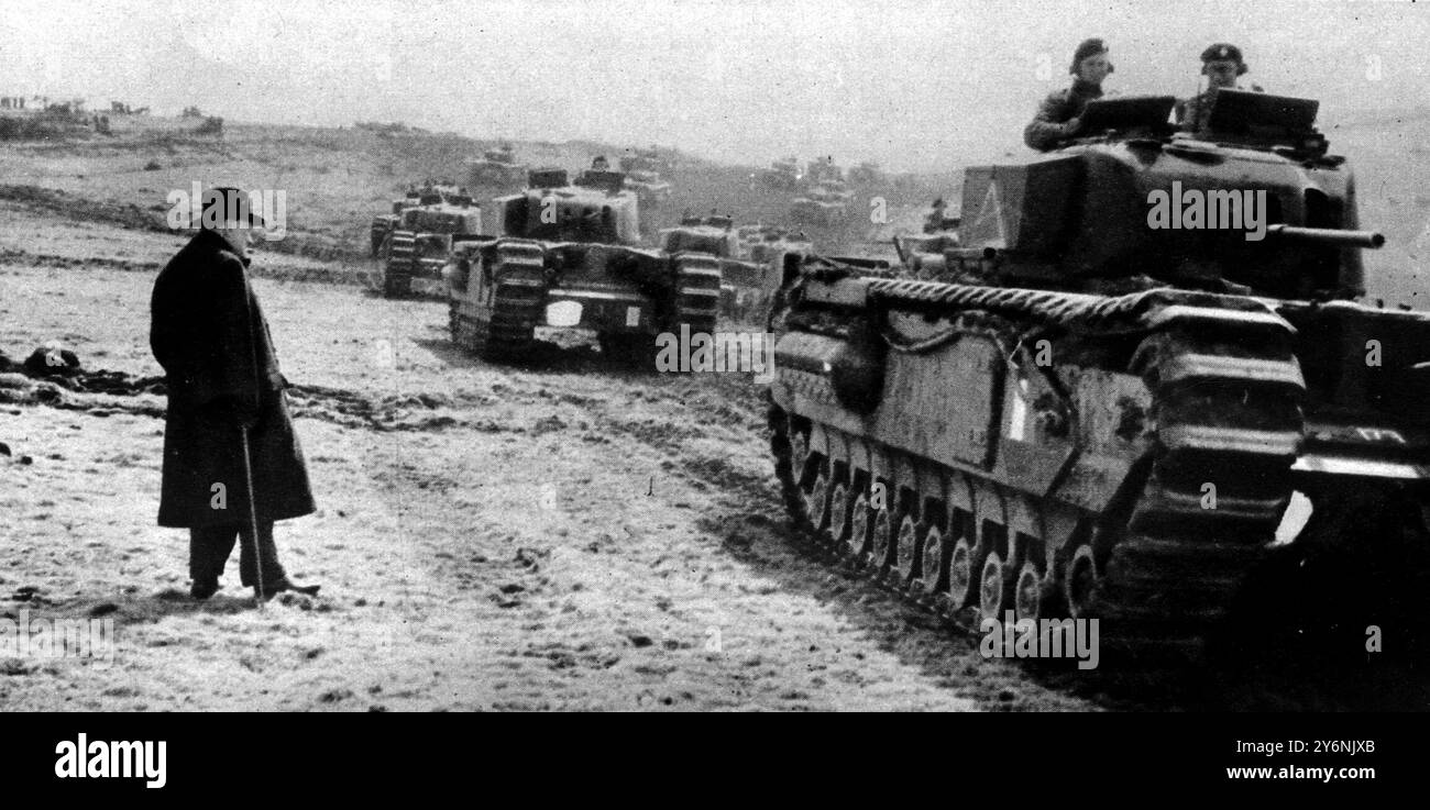 A column of Churchill tanks on the move watched appreciatively by the ...