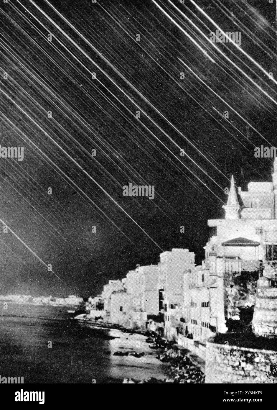 Tracer shells sear the night sky, while gun flashes light up waterside ...