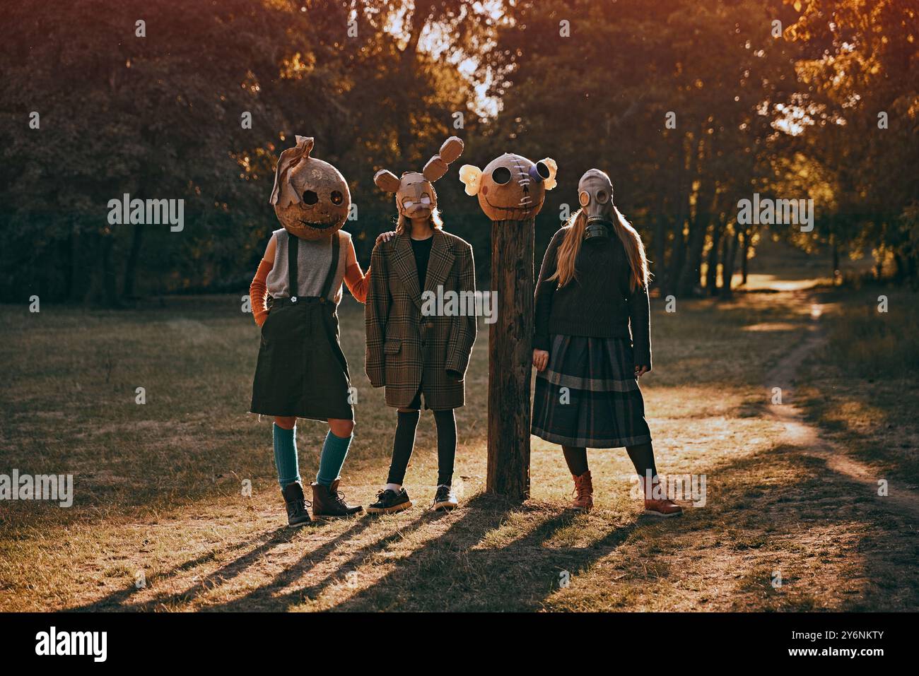 Group of people in creepy masks and odd clothes standing in autumn ...
