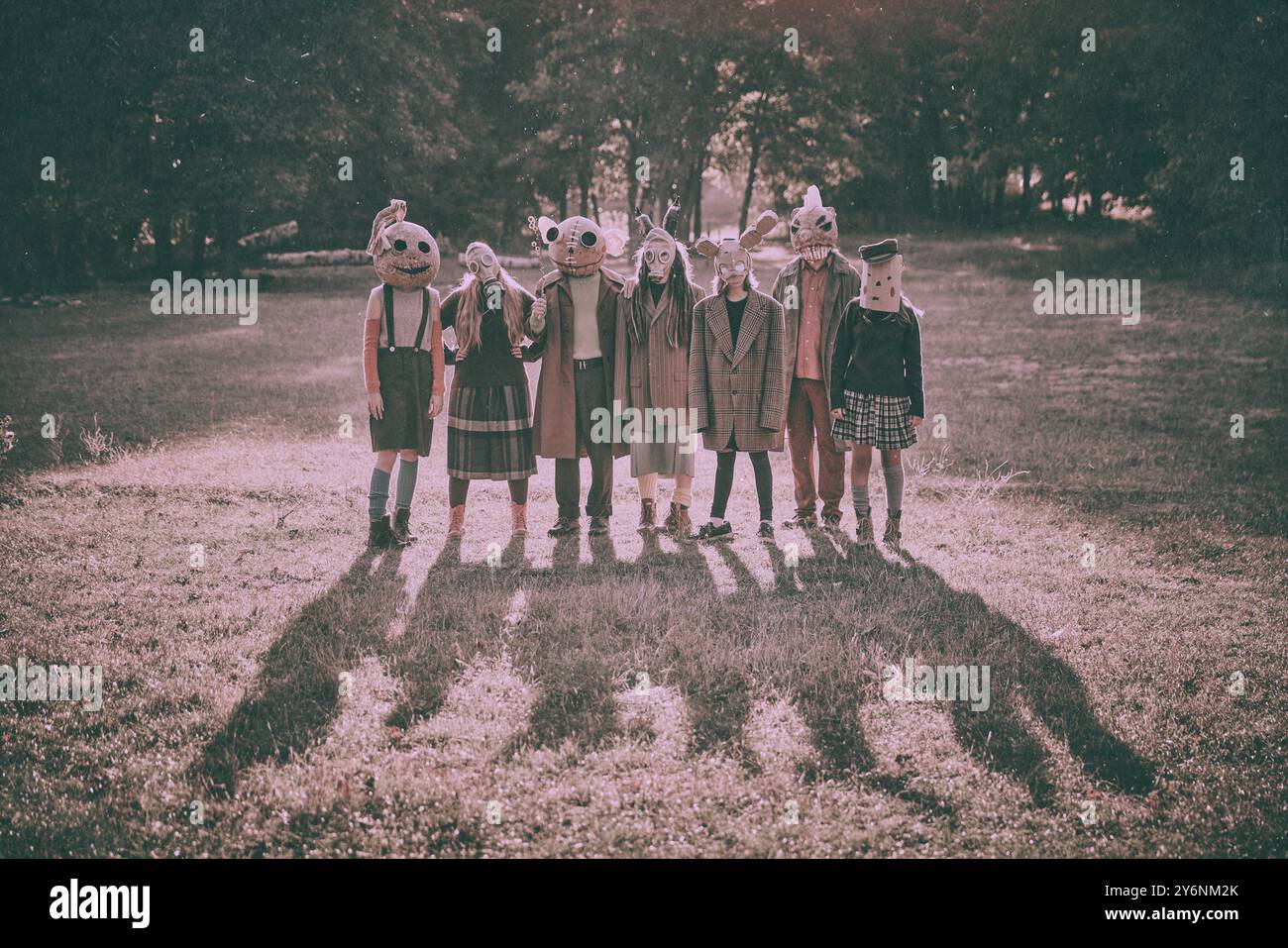 Group of people in creepy masks and odd clothes standing in autumn ...