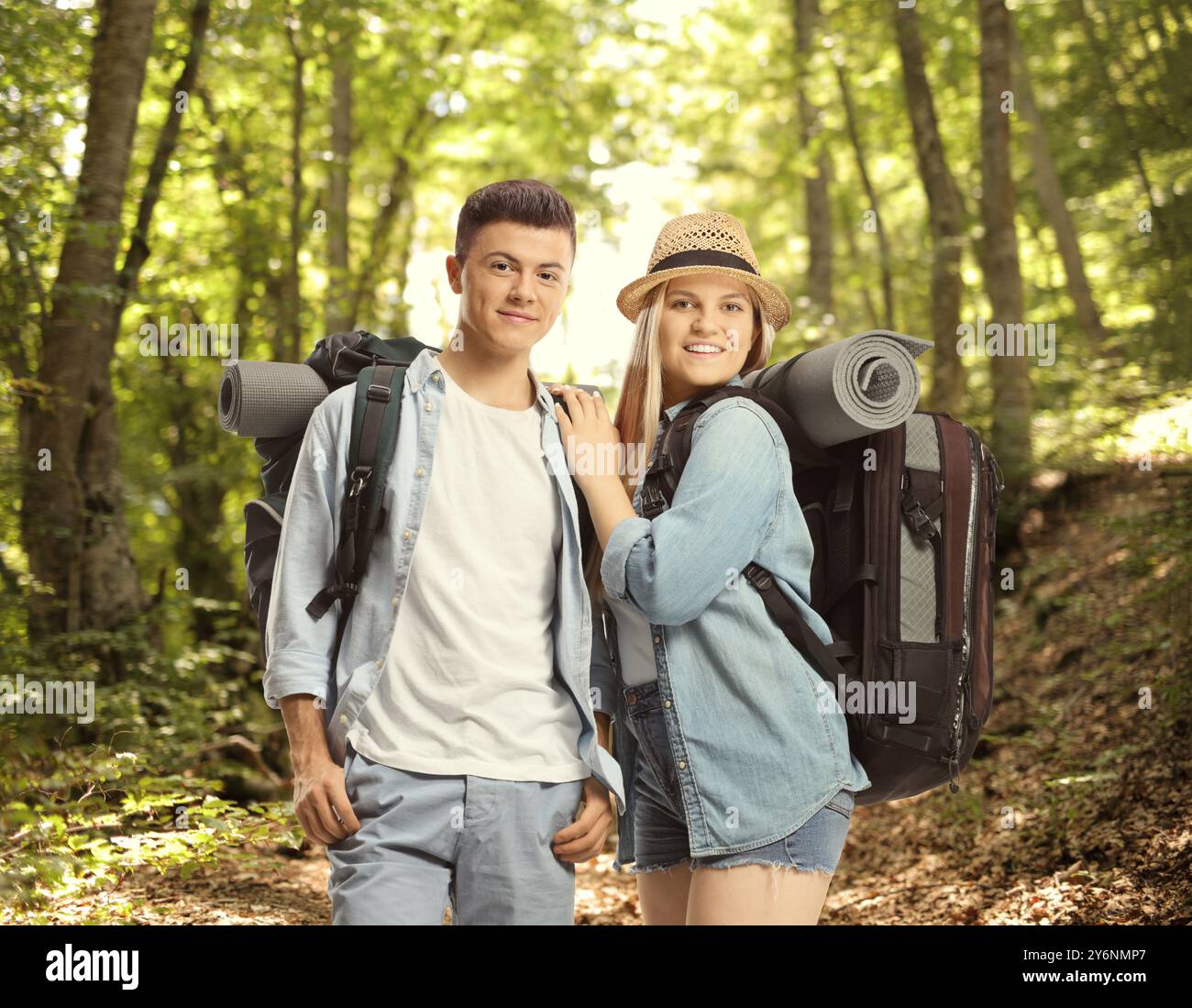 Young male and female backpackers in a forest, mountain climbing ...