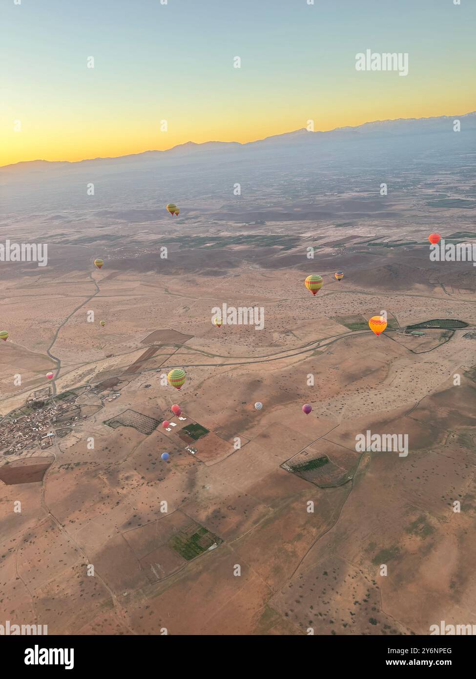 An aerial view of hot air balloons flying over a desert in Marrakesh ...