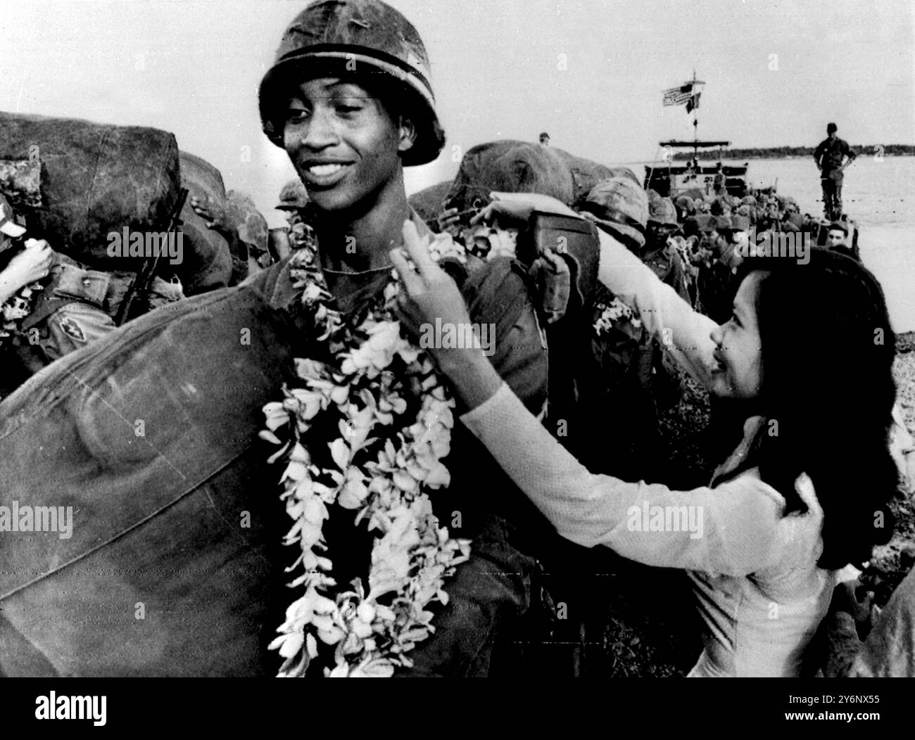 An American Soldier of the 25th division smiles as a Vietnamese girl ...