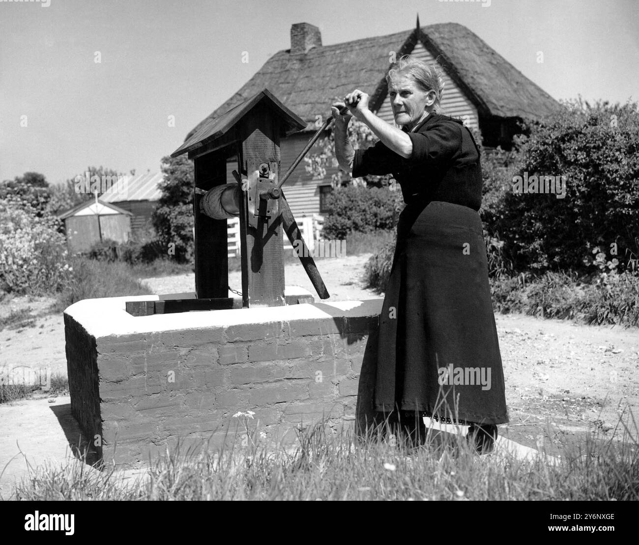 Old lady drawing water from a well Stock Photo - Alamy