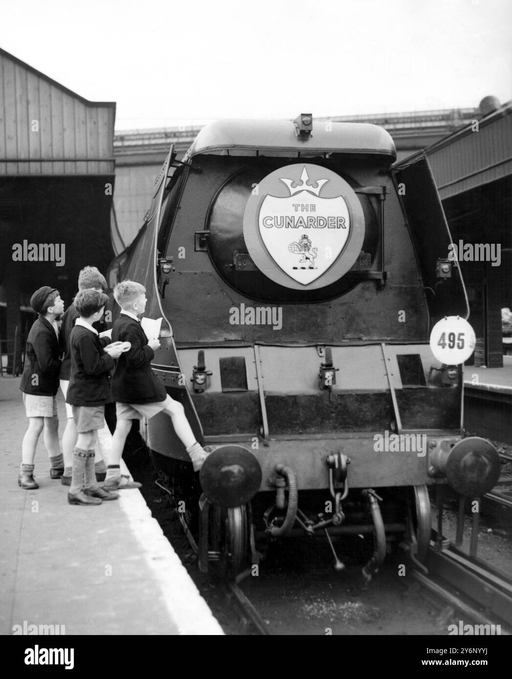 Youthful railway 'collectors' peer at the nameboard of the Cunard ...