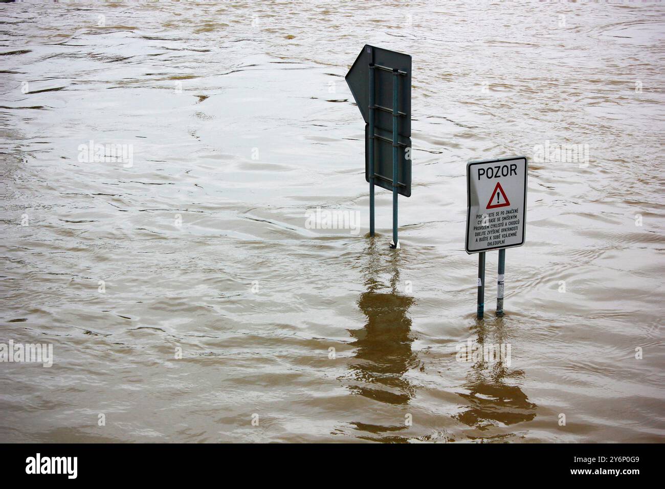 Two road signs, one of them with a Czech inscription, inundated by ...