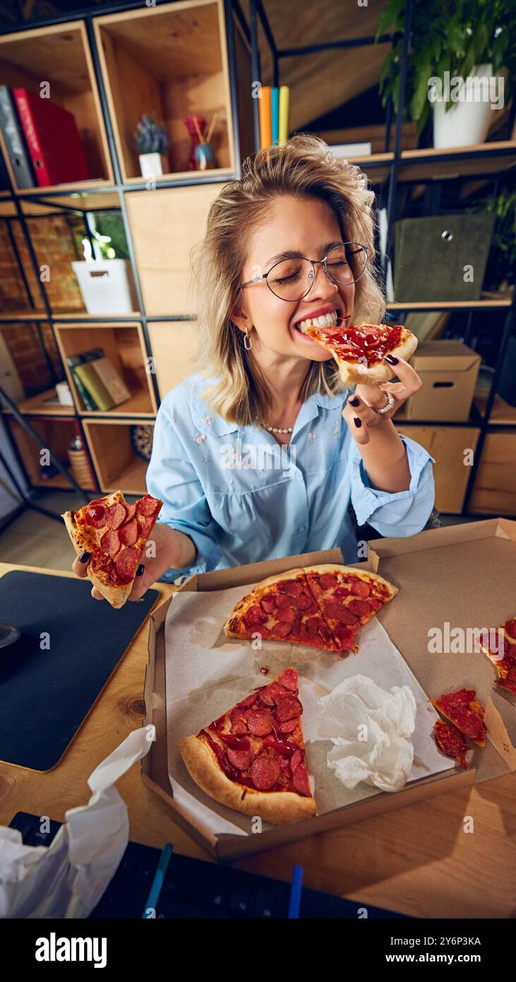 Employee eating pizza, seemingly unaware of how this habit is affecting ...