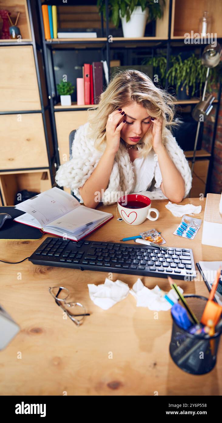 Headache at work, employee rubs their temples, looking stressed and ...