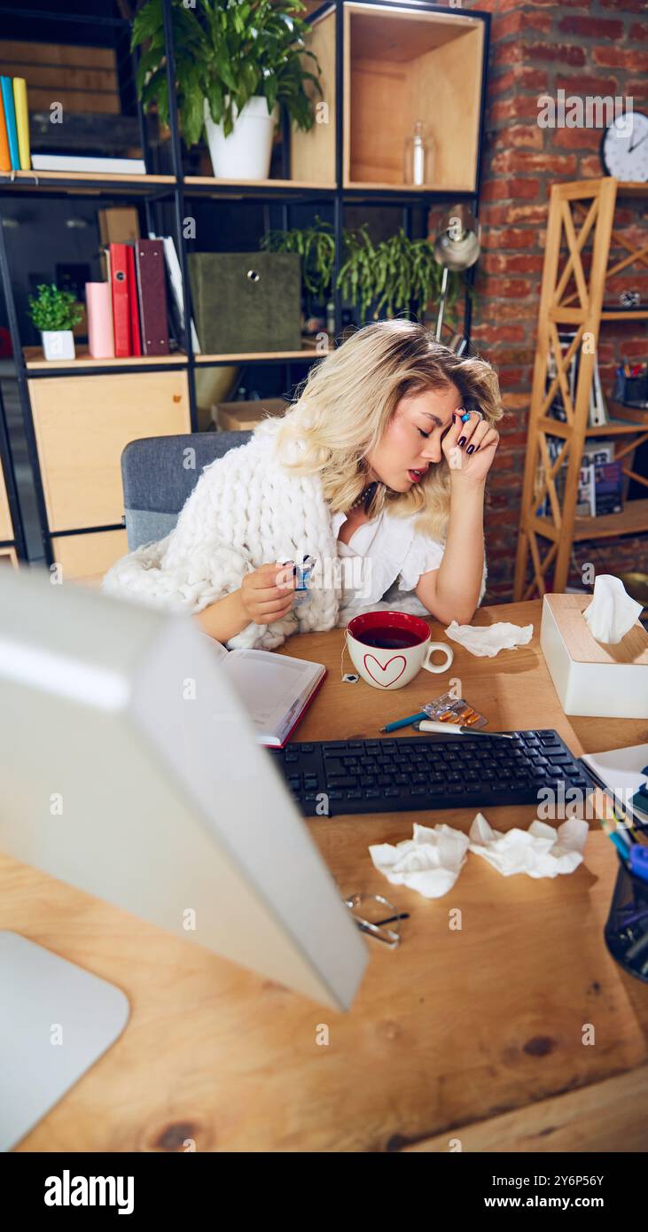Overwhelmed worker takes moment to rest their head on desk. Feeling ...