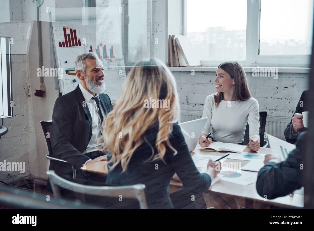 Happy business people communicating with each other and smiling while ...
