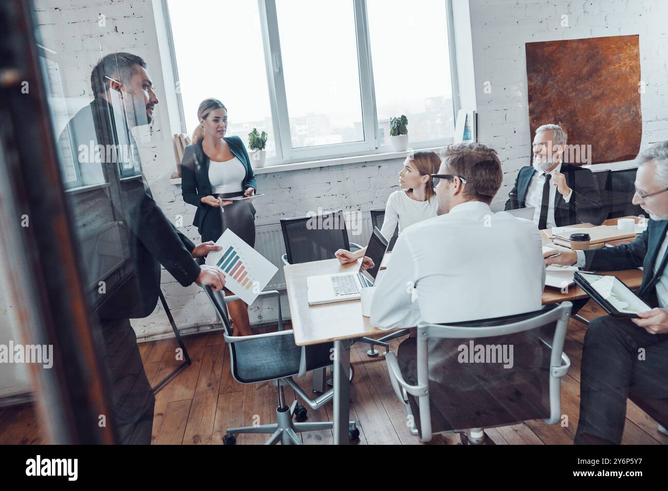 Successful business team analyzing sales while having staff meeting in ...