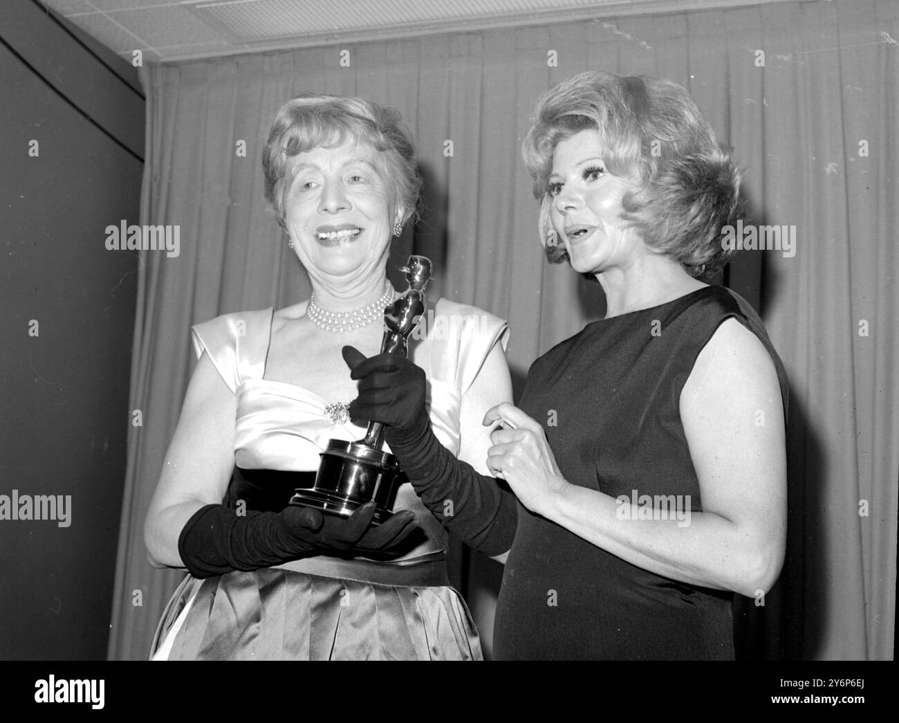 British Actree Dame Edith Evans clutches the Motion Picture Academy Award presented to her by ...