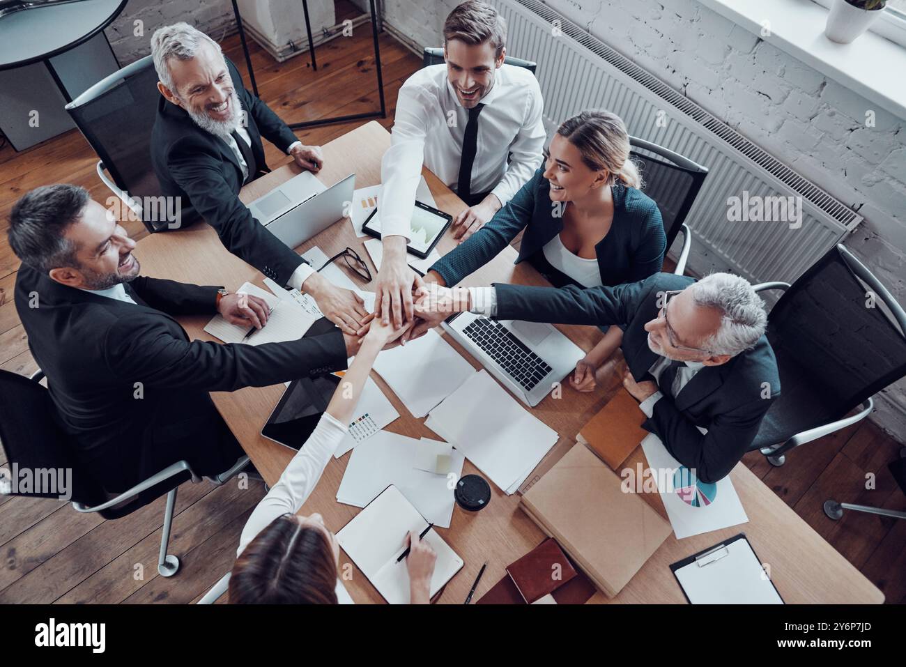 Top view of cheerful business team keeping hands together as a symbol ...